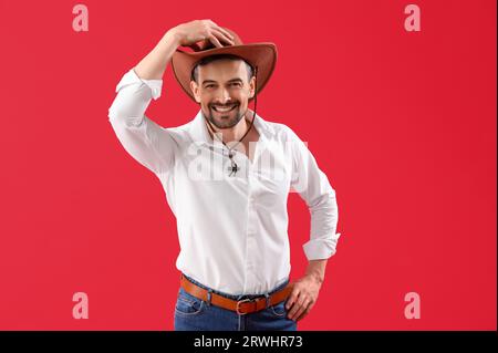 Handsome cowboy on red background, back view Stock Photo - Alamy