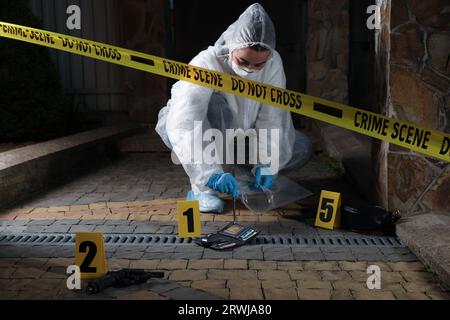 Investigator and criminologist working with evidences at crime scene near car outdoors Stock ...