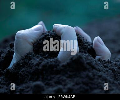 Hand emerging from the ground trough the soil Stock Photo - Alamy