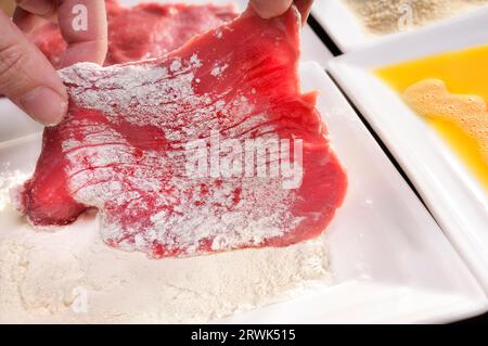 Turn meat in flour Stock Photo - Alamy