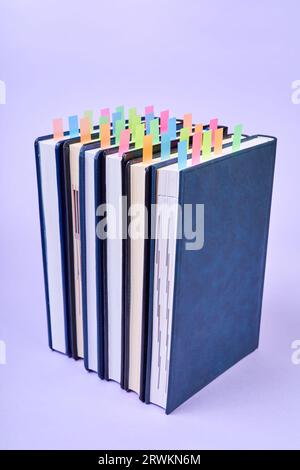 Stack of office notepads on purple background Stock Photo - Alamy