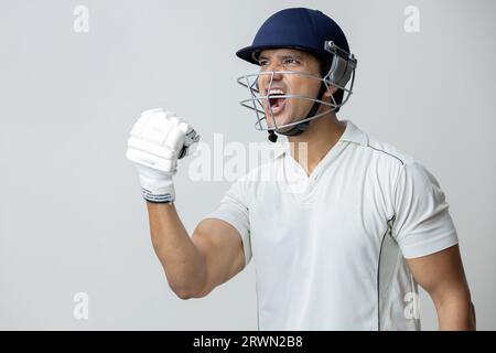 Man In cricket dress with helmet screaming in joy and anger, Cricketer ...
