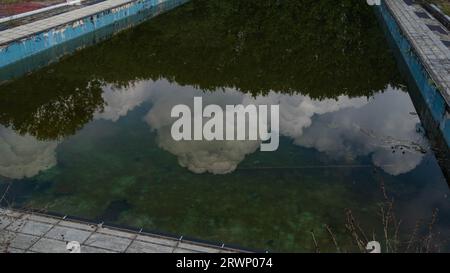 Old swimming pool center full of trash, rubbish, overgrown facility in ...