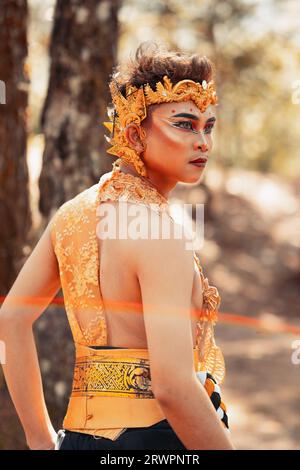 Manly Asian man posing in a golden crown and golden clothes while ...