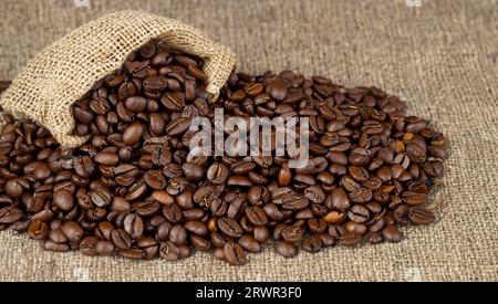 Coffee beans on gunny sack background Stock Photo - Alamy