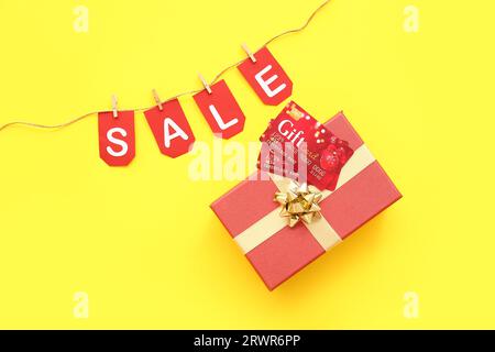 Credit cards, rope, clothespins and flags with word SALE on yellow ...