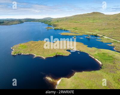 Aerial view of the freshwater loch Loch Assynt with small tree islands ...