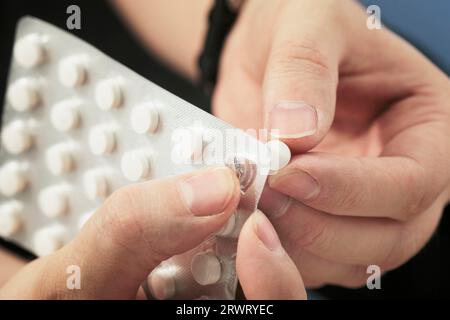 Hands taking tablet out blister Stock Photo - Alamy