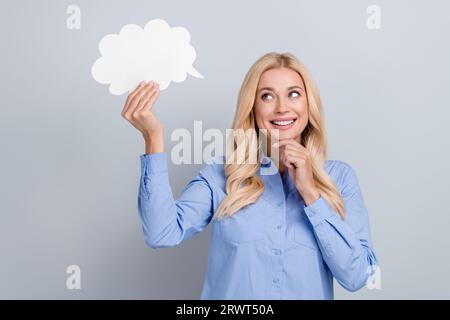 Portrait of minded attractive girl hand touch chin hold paper like card ...