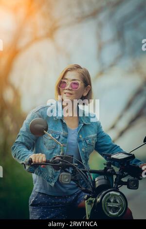 pretty woman riding small enduro motorcycle crossing shallow creek ...