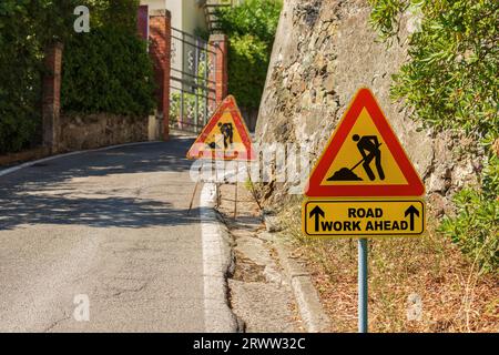 Triangular orange, red and black road work ahead sign or work in ...