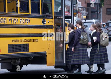 Orthodox Jewish classmates wearing the same tartan skirts cross a ...