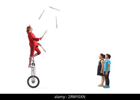 Boy and girl watching an acrobat riding a giraffe unicycle isolated on ...