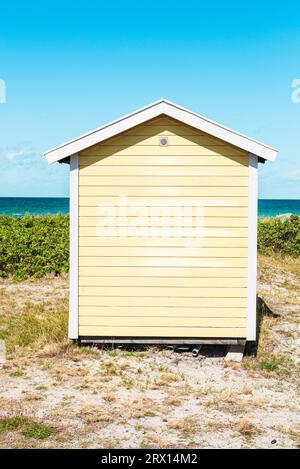 Frontal view of the back of a yellow wooden bathing hut on the beach of ...