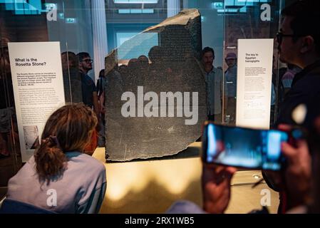 A tourist takes a photo of the Rosetta Stone on display in the British ...