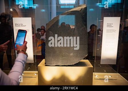 A tourist takes a photo of the Rosetta Stone on display in the British ...