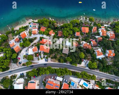 Aerial view of luxury terracotta villa rooftops above Mediterranean Sea ...
