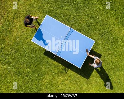 Aerial view people playing ping pong match outdoor. Top view two boys ...