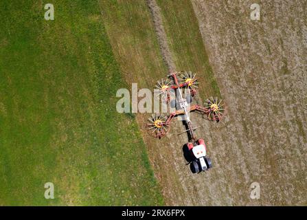 Drone view of tractor with rotary rakes turning hay Stock Photo - Alamy