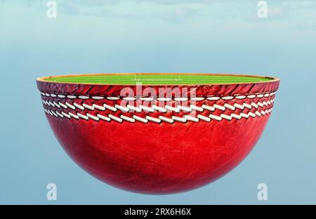 A cricket ball split in half revealing a marked green grass cricket ...
