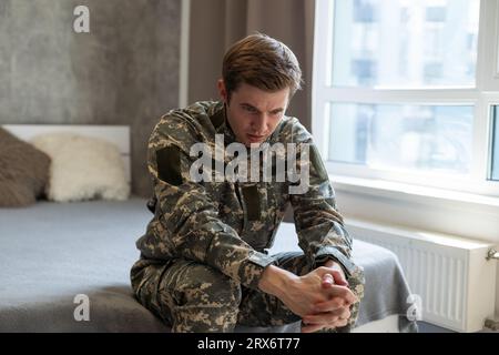 Stressed veteran soldier engrossed in depressive thoughts and memories ...