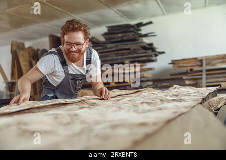 Carpenter measures wooden planks in the workshop Stock Photo - Alamy