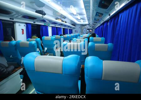 Executive class train interior with blue seats, armrests, luggage racks ...