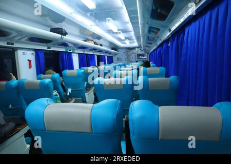 Executive class train interior with blue seats, armrests, luggage racks ...