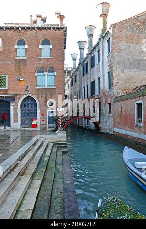 Small wooden bridge over narrow canal and typical colorful houses in ...