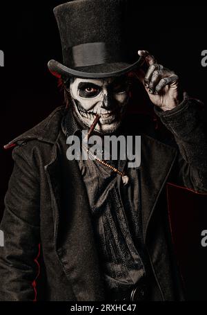 Cheerful man dressed as a scary zombie poses over a black background ...