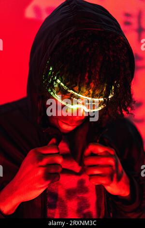 Studio portrait with red neon lights of a stylish futuristic man posing ...