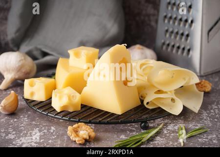 Stand with pieces of Swiss cheese and walnut on grey background Stock ...