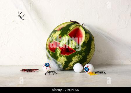Carved watermelon for Halloween with eyes and spiders on white ...