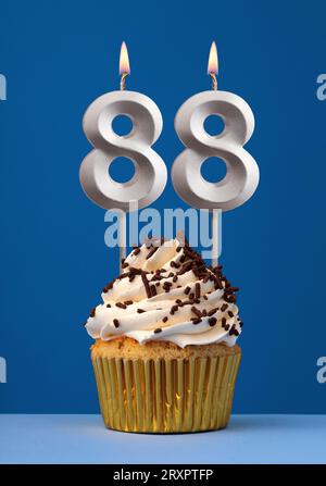 Birthday number 88 - Candle lit on blue background Stock Photo - Alamy