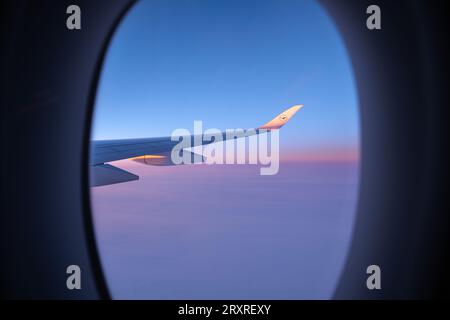 Lufthansa airplane wing seen through an oval window. View on a North ...