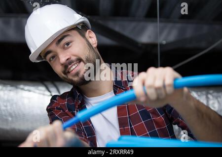 builder holding blue pipes in construction site Stock Photo - Alamy