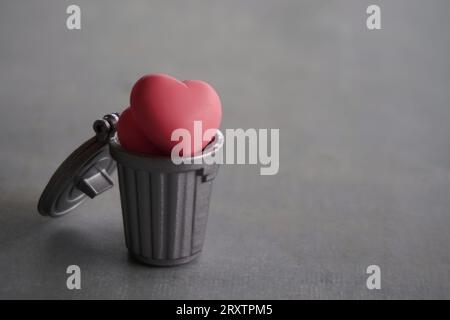 Closeup image of heart inside trash can with copy space. Broken heart ...