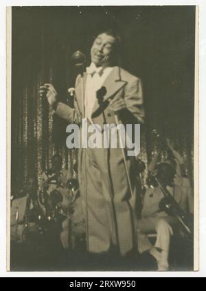 B & W photograph of Cab Calloway conducting band members. Calloway and ...