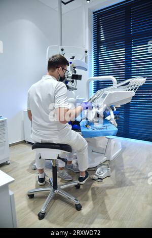 Professional dentist surgeon and assistant performing dental operation ...