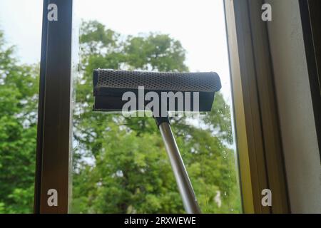 cleaning the window with a window cleaning mop closeup. Cleaning ...