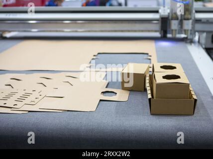 Digital die cut machine cutting corrugated cardboard. Industrial ...