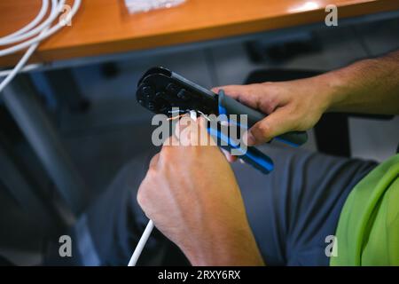 Unrecognizable hand cutting ethernet network cable with tool for ...