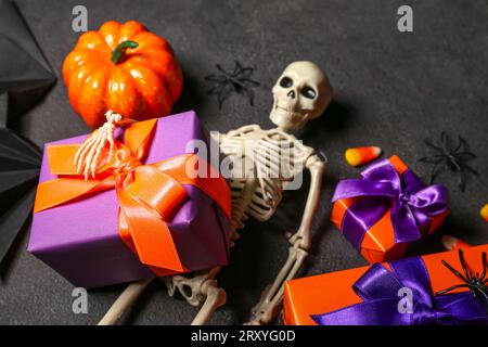 Composition with beautiful gift boxes and skeleton for Halloween on ...