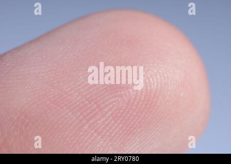 Finger with friction ridges on light blue background, macro view Stock ...
