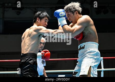 Eigoro Akai (red gloves) hits Ryohei Ibuki (blue gloves) in the second ...