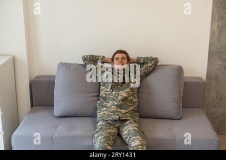Soldier napping on soft sofa in living room. Military service Stock ...