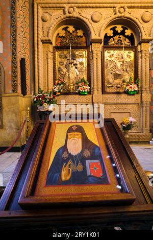 An Orthodox Christian priest with a long white beard sits reading a ...
