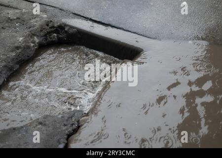 Dirty AODOn road. Puddle after rain. Wastewater on street. Dirt in city ...