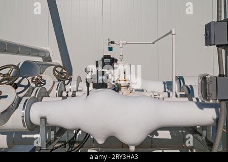 White insulated piping mounted on roof of cold storage facility, for ...