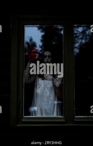 Spooky ghost looking through glass window of haunted cabin Stock Photo ...